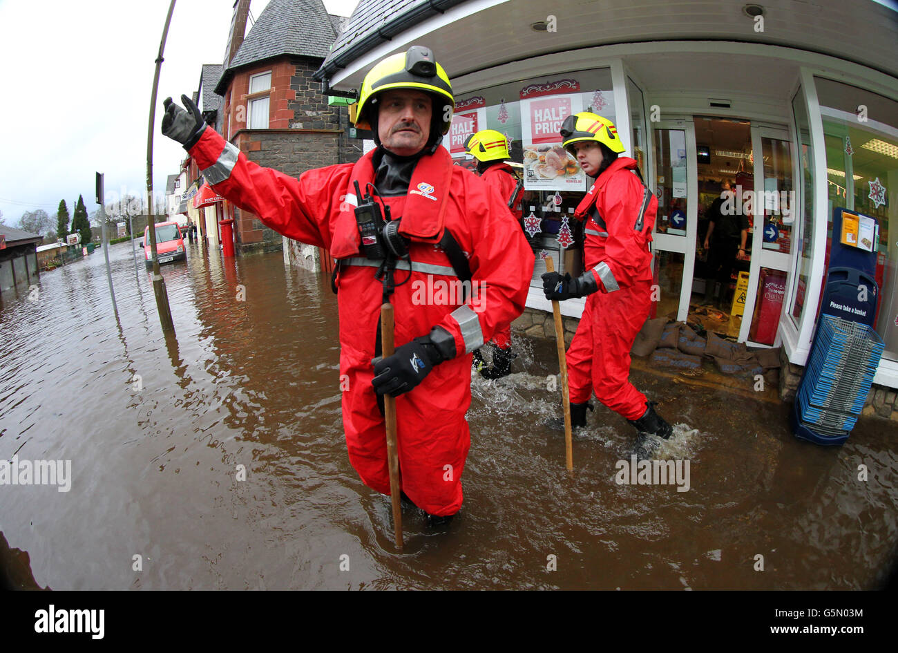 Firemen wade through Aberfoyle which has been flooded after the River ...