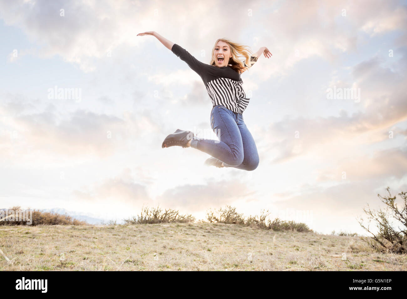 Caucasian teenage girl jumping for joy Stock Photo - Alamy