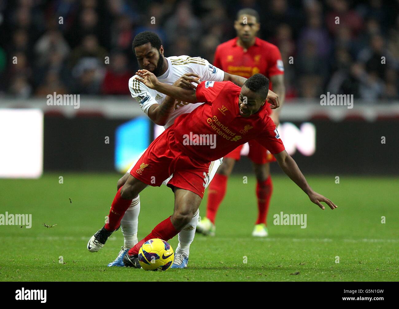 Liverpool's Raheem Sterling and Swansea City's Kemy Agustien (behind ...