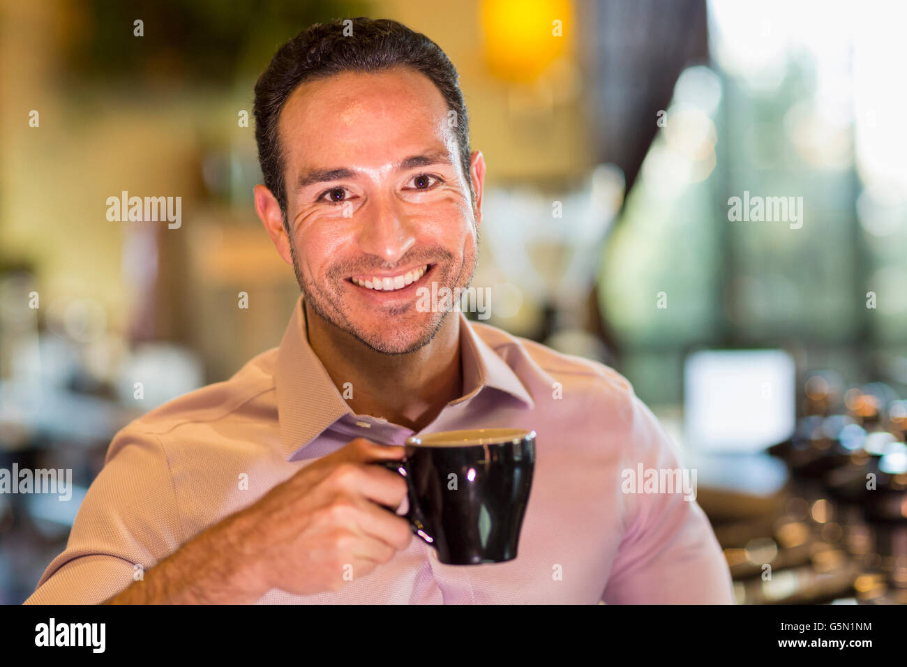 Hispanic barista drinking coffee in coffee shop Stock Photo - Alamy