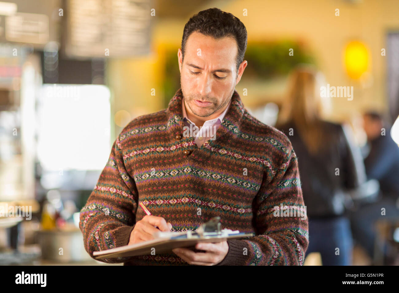 Hispanic businessman writing in coffee shop Stock Photo - Alamy