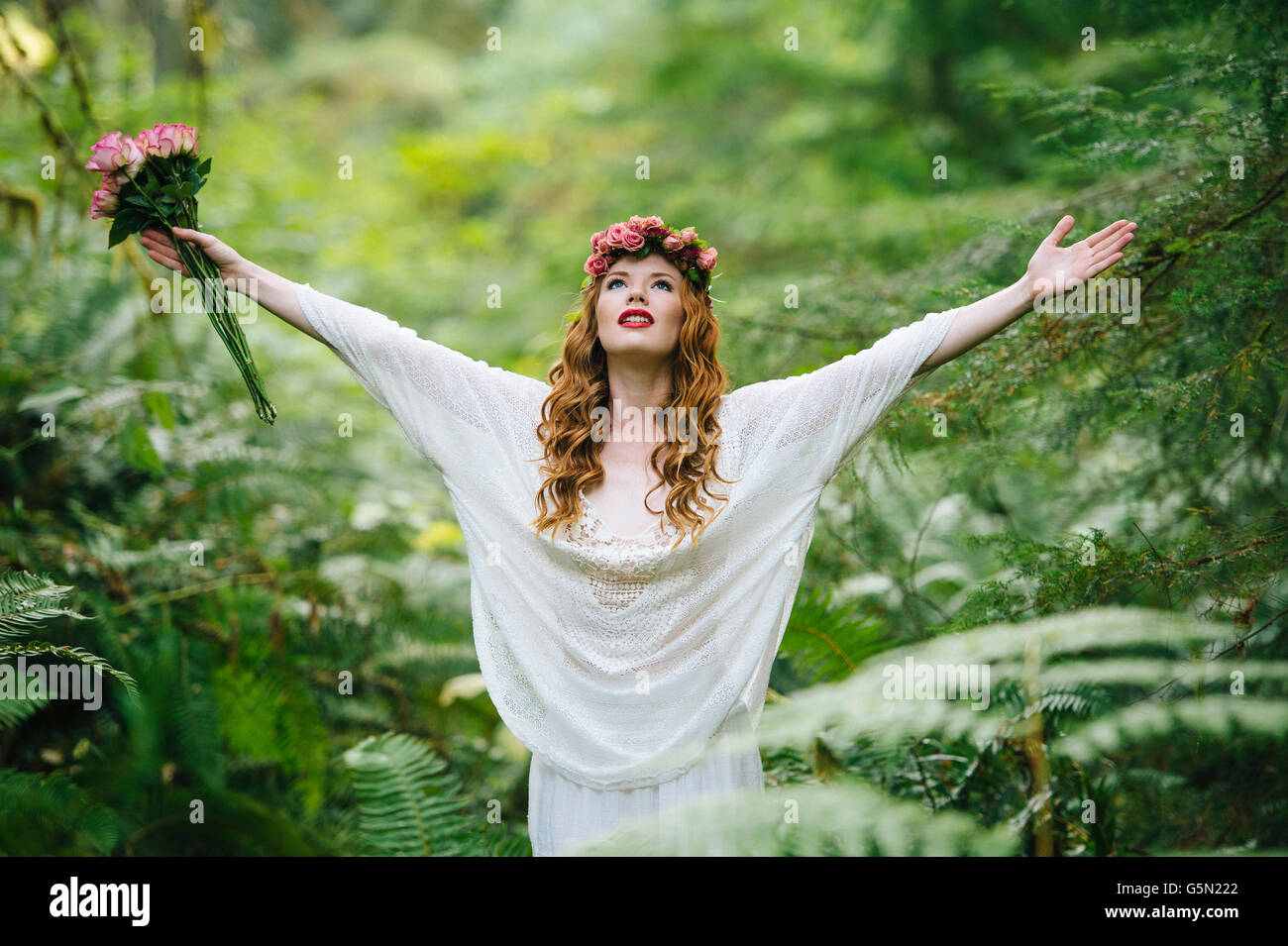 Caucasian woman wearing flower crown in forest Stock Photo - Alamy