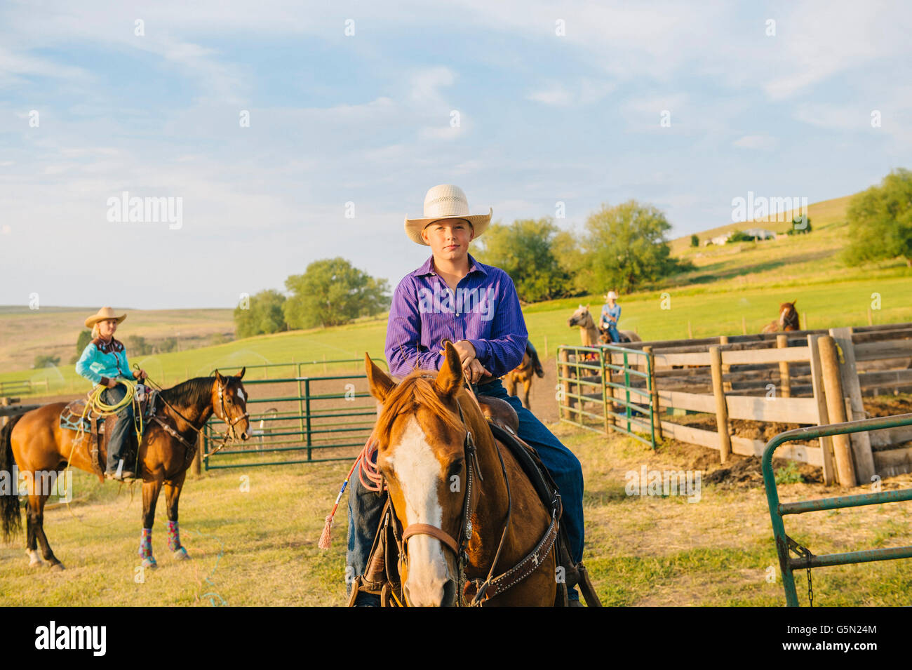 Cowboy riding horseback on ranch Stock Photo - Alamy