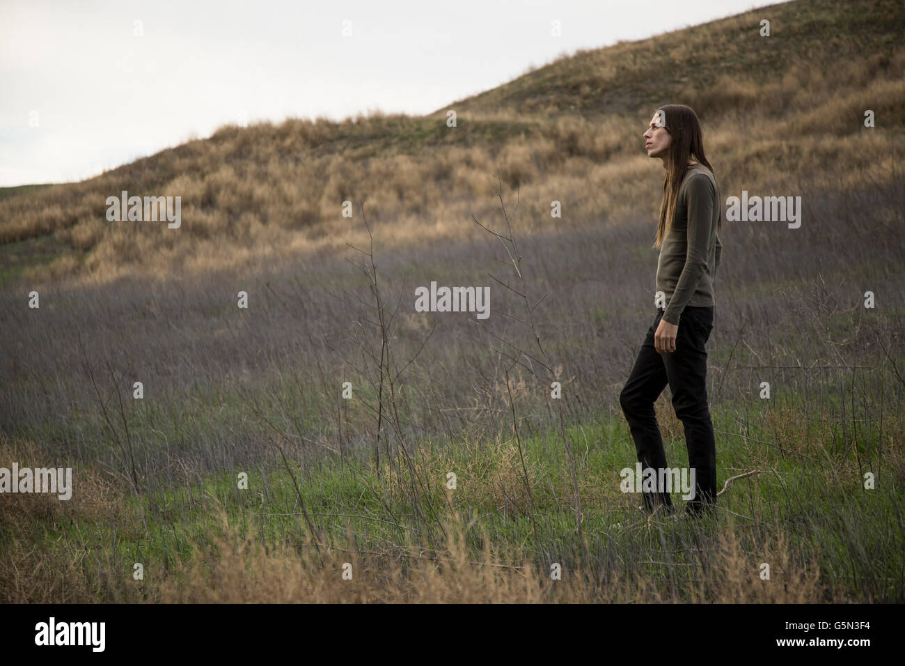 Man walking in rural field Stock Photo - Alamy