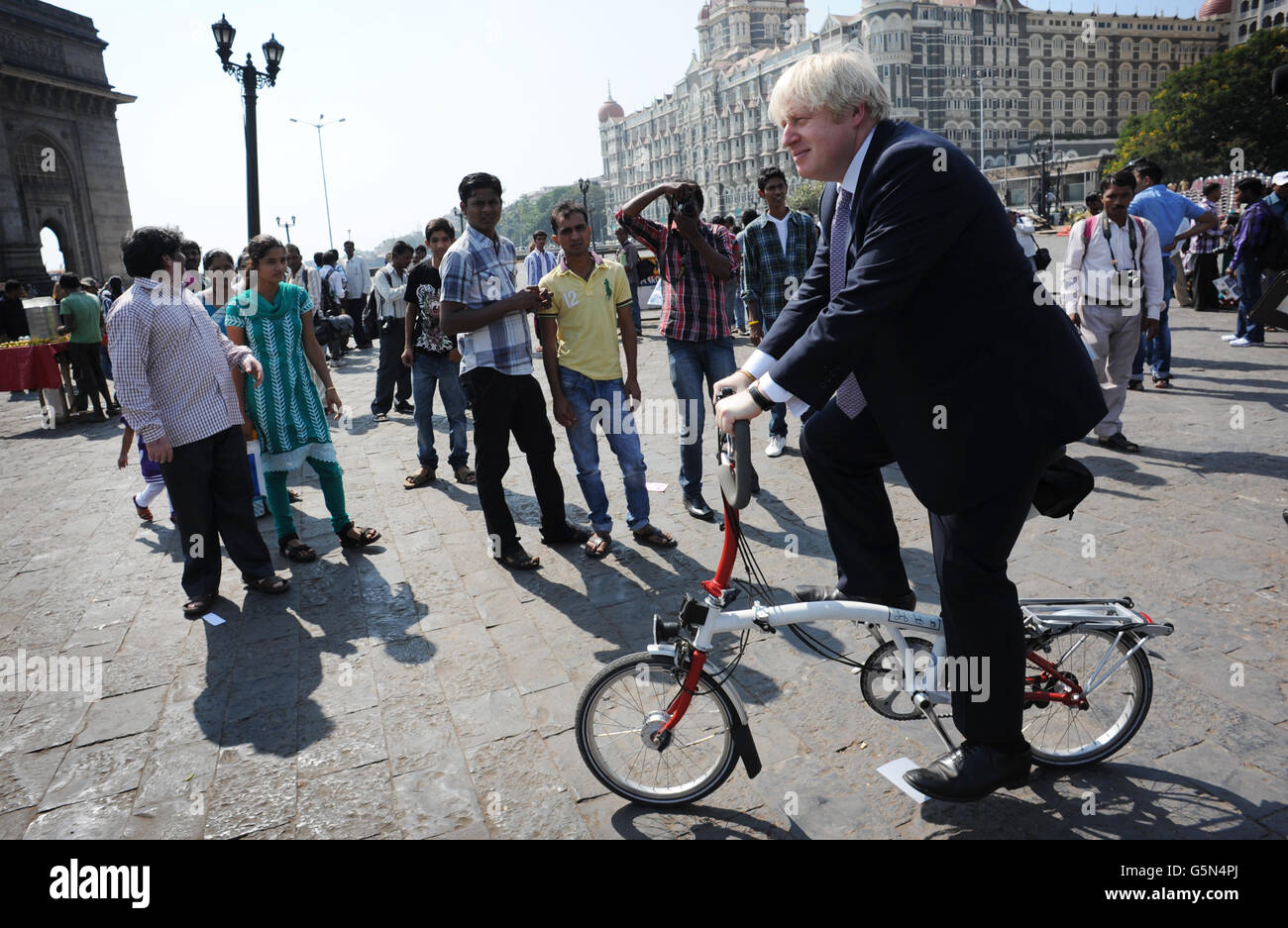 London mayor Boris Johnson rides a bicycle around the Gate of India in ...