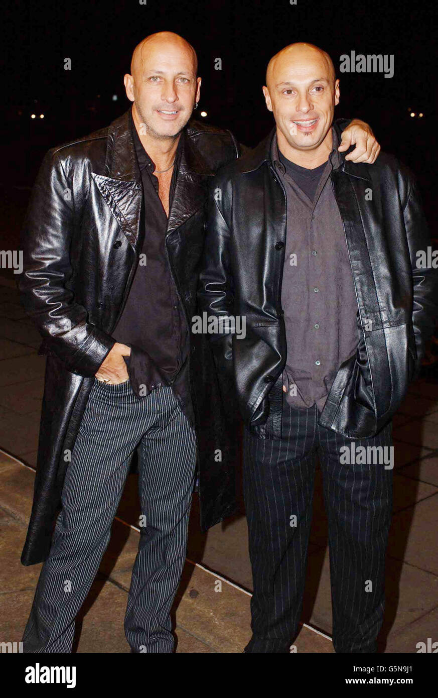 Celebrity black leather coat arm around brother pinstripe trousers hi ...