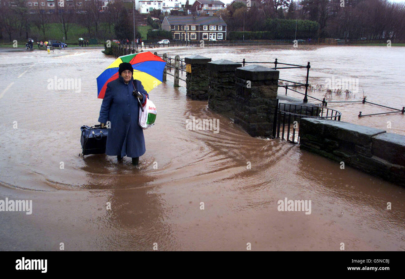 A local woman trudges home across the River Usk which burst its banks ...