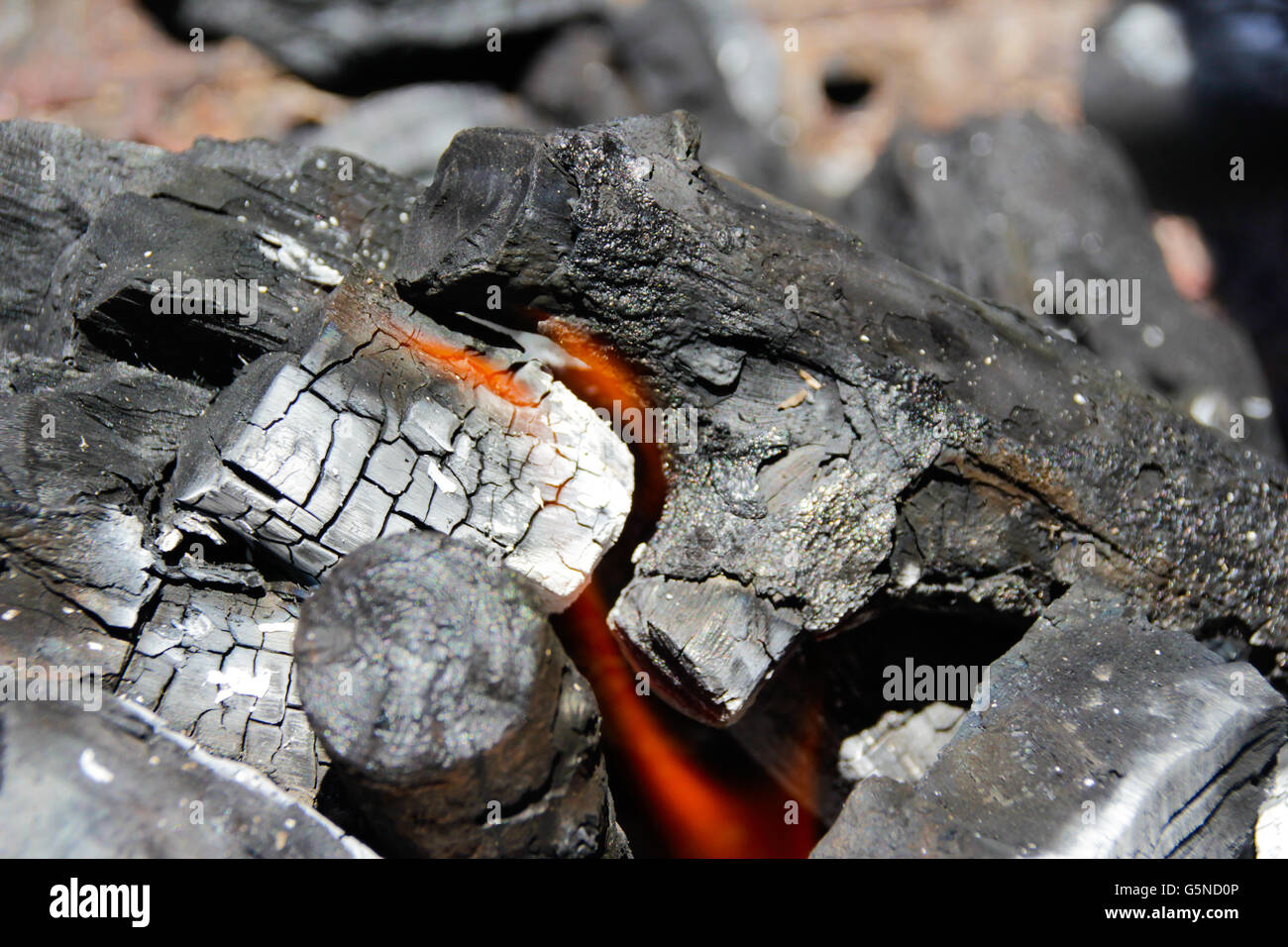 Photograph of some wood charcoal pieces and fire flames Stock Photo - Alamy