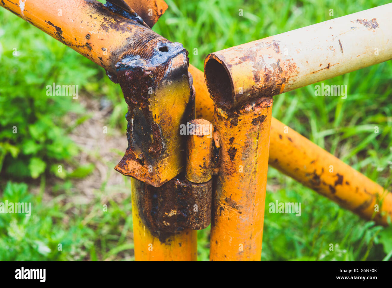 old rusty yellow pipe on a background of green grass Stock Photo - Alamy