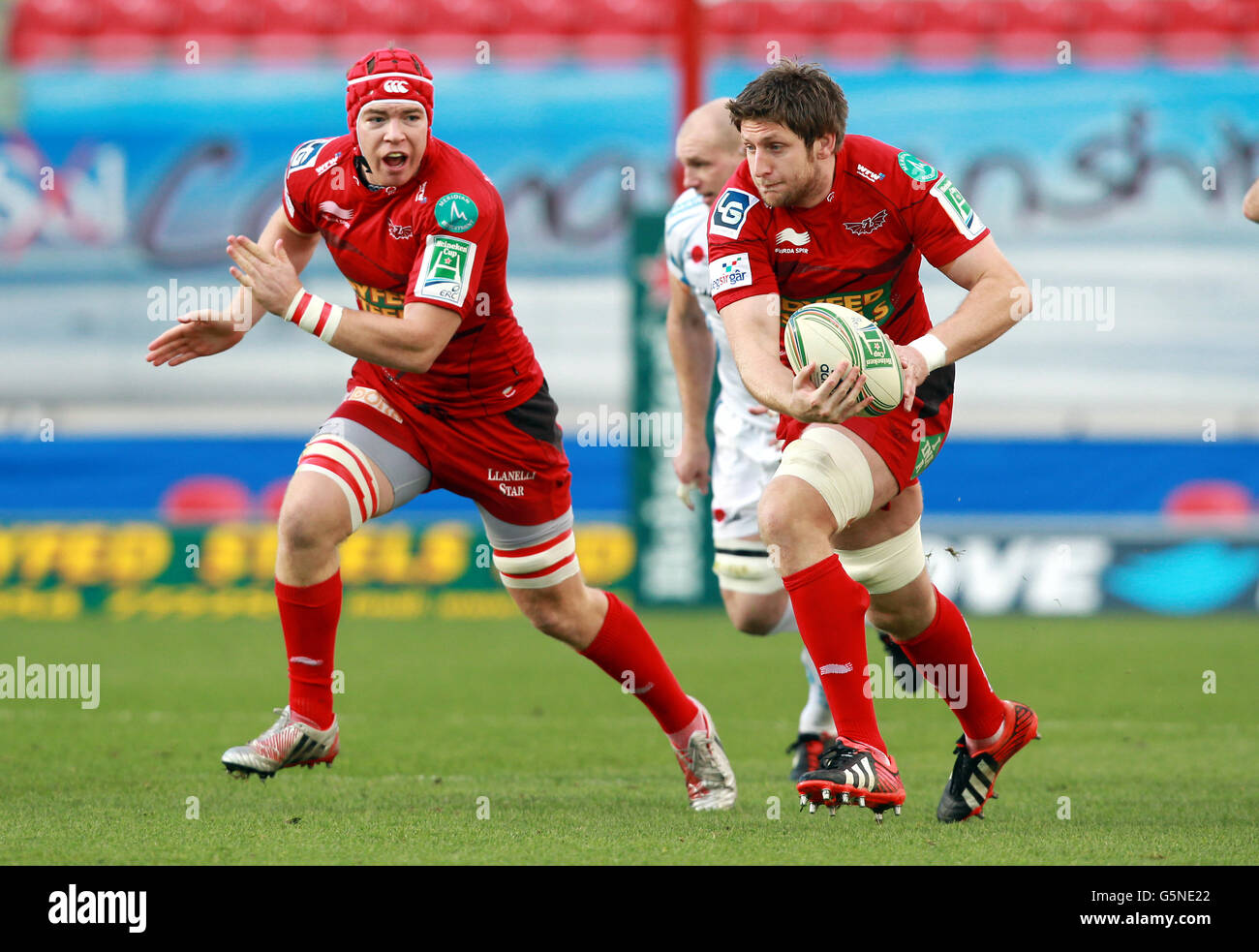 Llanelli Scarlets' Richard Kelly supported by Kieran Murphy breaks away ...