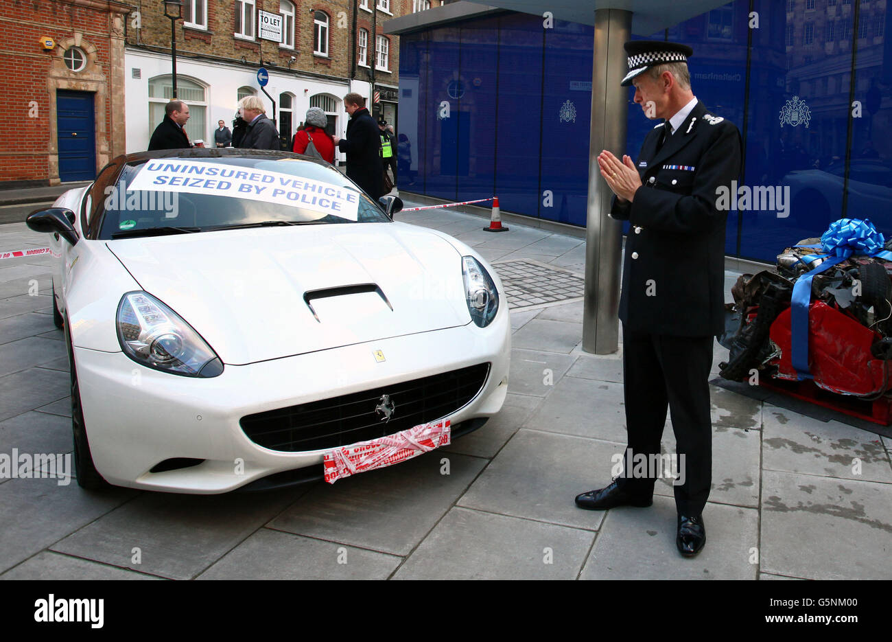 Metropolitan Police Commissioner Bernard Hogan-Howe stands next to a ...
