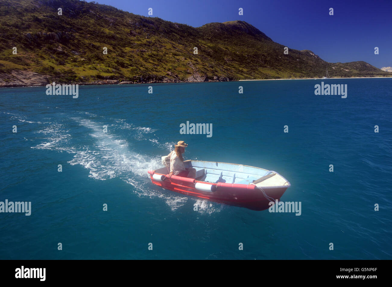 Man driving red dinghy in Watson's Bay, Lizard Island, Great Barrier ...