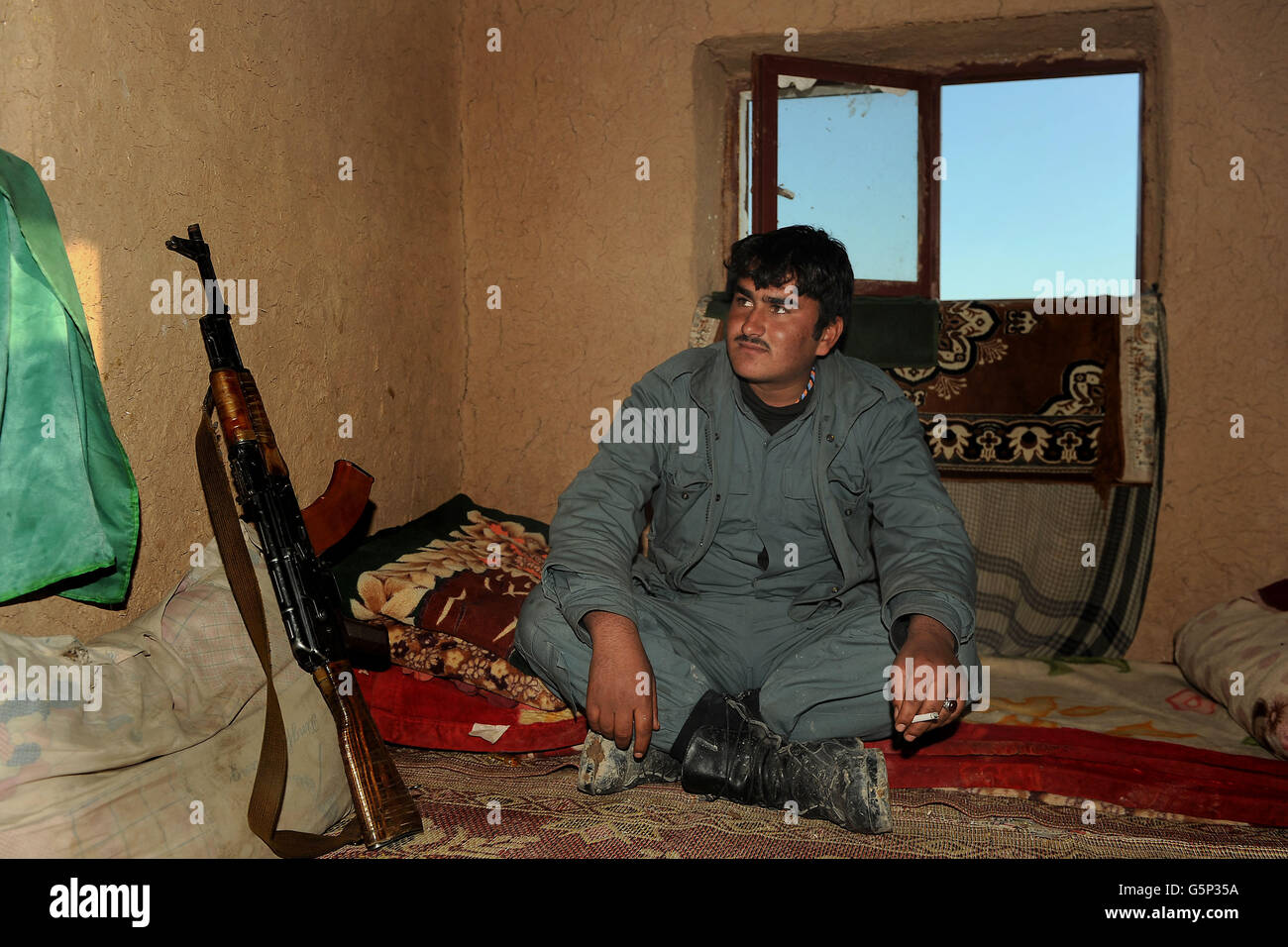 A member of the Afghan National Police takes a break from his post at ...