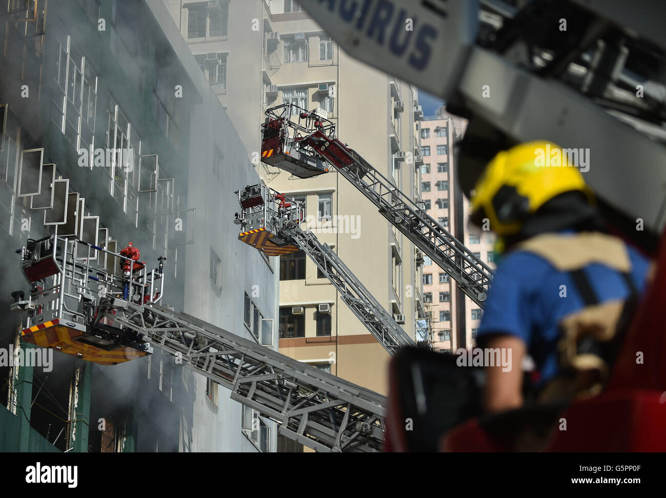 Hong Kong, China. 23rd June, 2016. Firefighters work to put out fire at ...