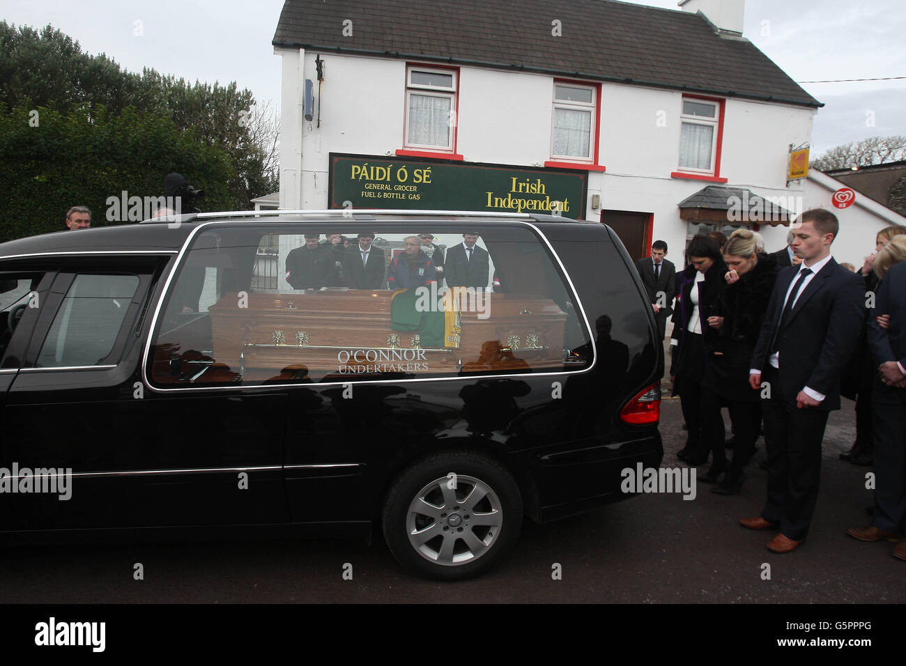 The coffin of former gaelic footballer Paidi O Se pauses at the family ...