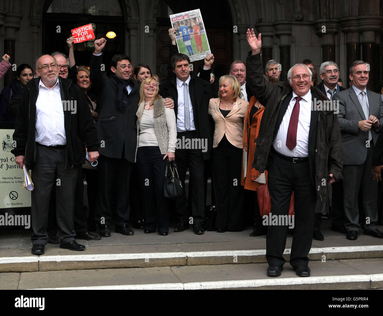 Trevor Hicks (front) waves as he comes out of the High Court in London ...