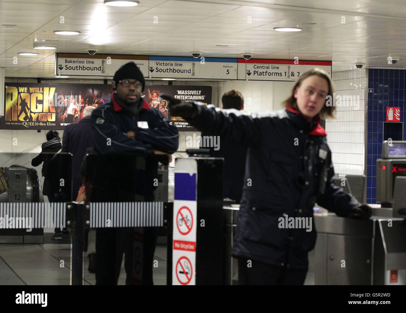 London Underground. A member of staff giving directions to passengers ...