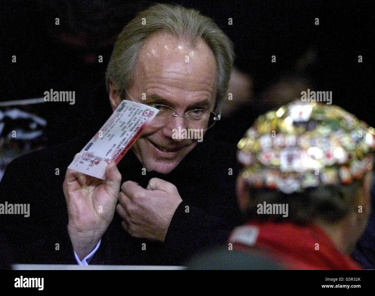 England Manager Sven Goran Eriksson shows his ticket to a fan sitting ...