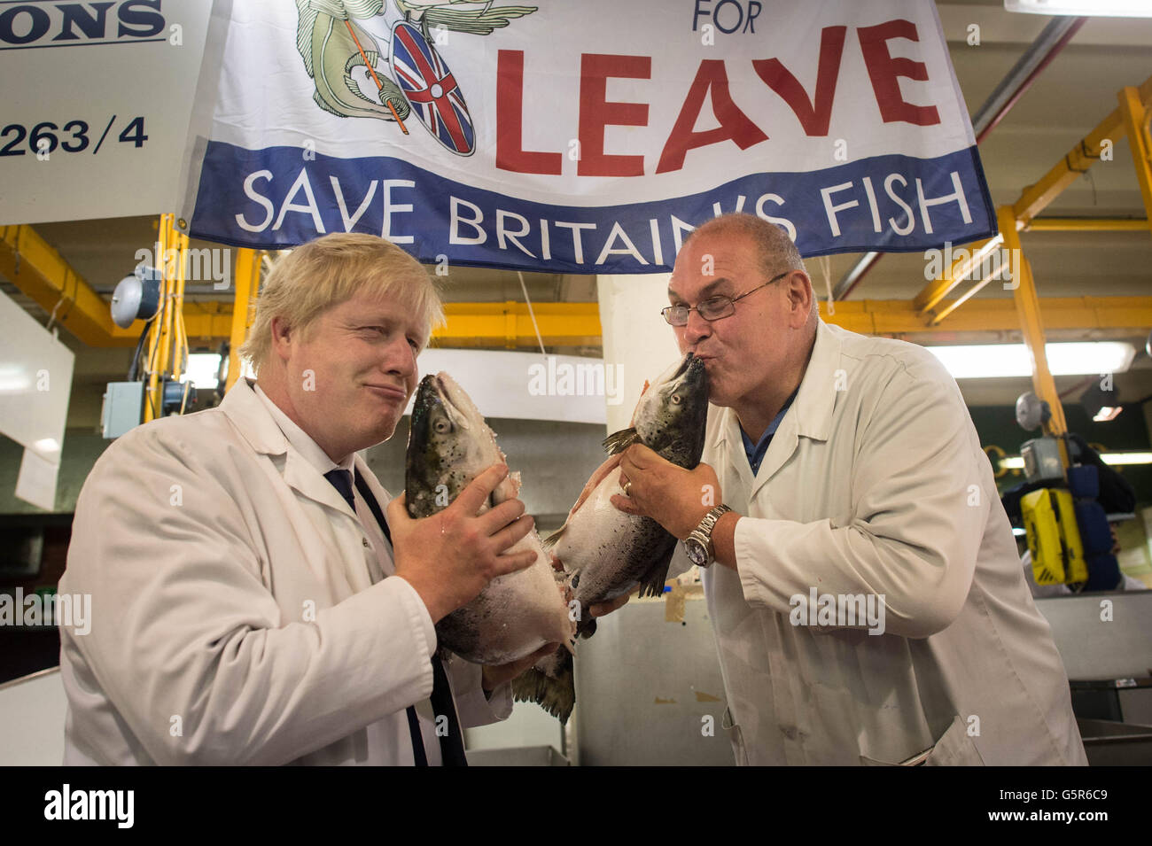 Boris Johnson (left) kisses a wild salmon as he is shown around ...