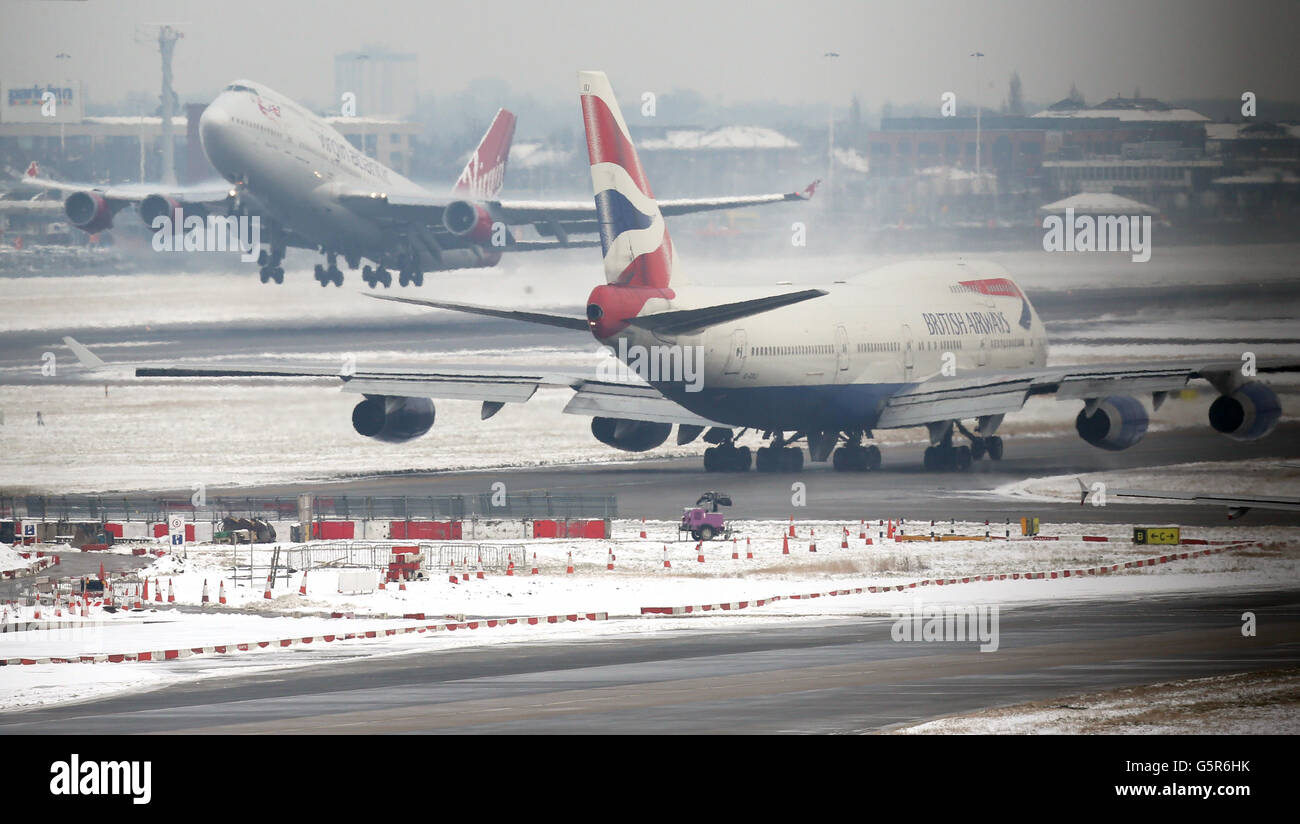 Planes take off and taxi at Heathrow Airport as the winter weather ...