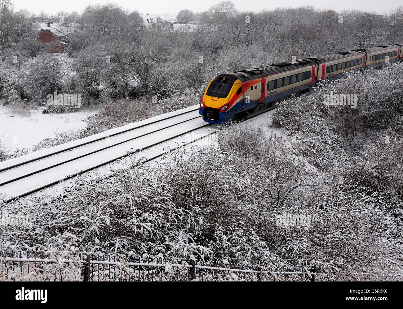 A train travelling down snowy railway tracks near Derby as the winter ...