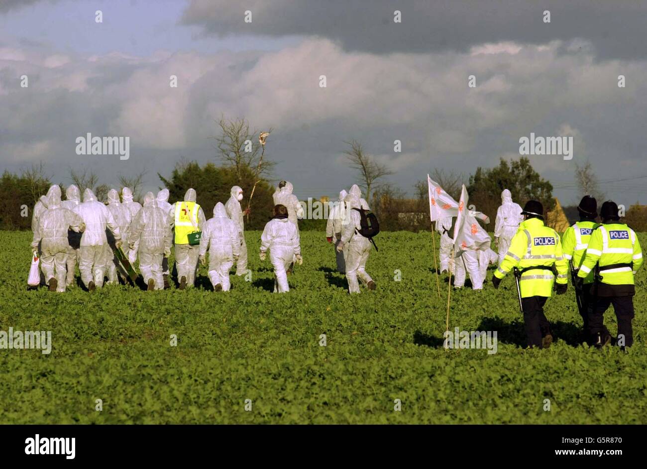 Police move in on white-suited protesters who ripped up parts of a ...