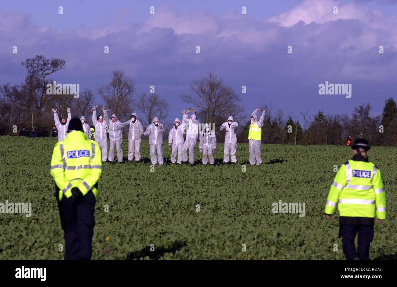 Police move in on white-suited protesters who ripped up parts of a ...
