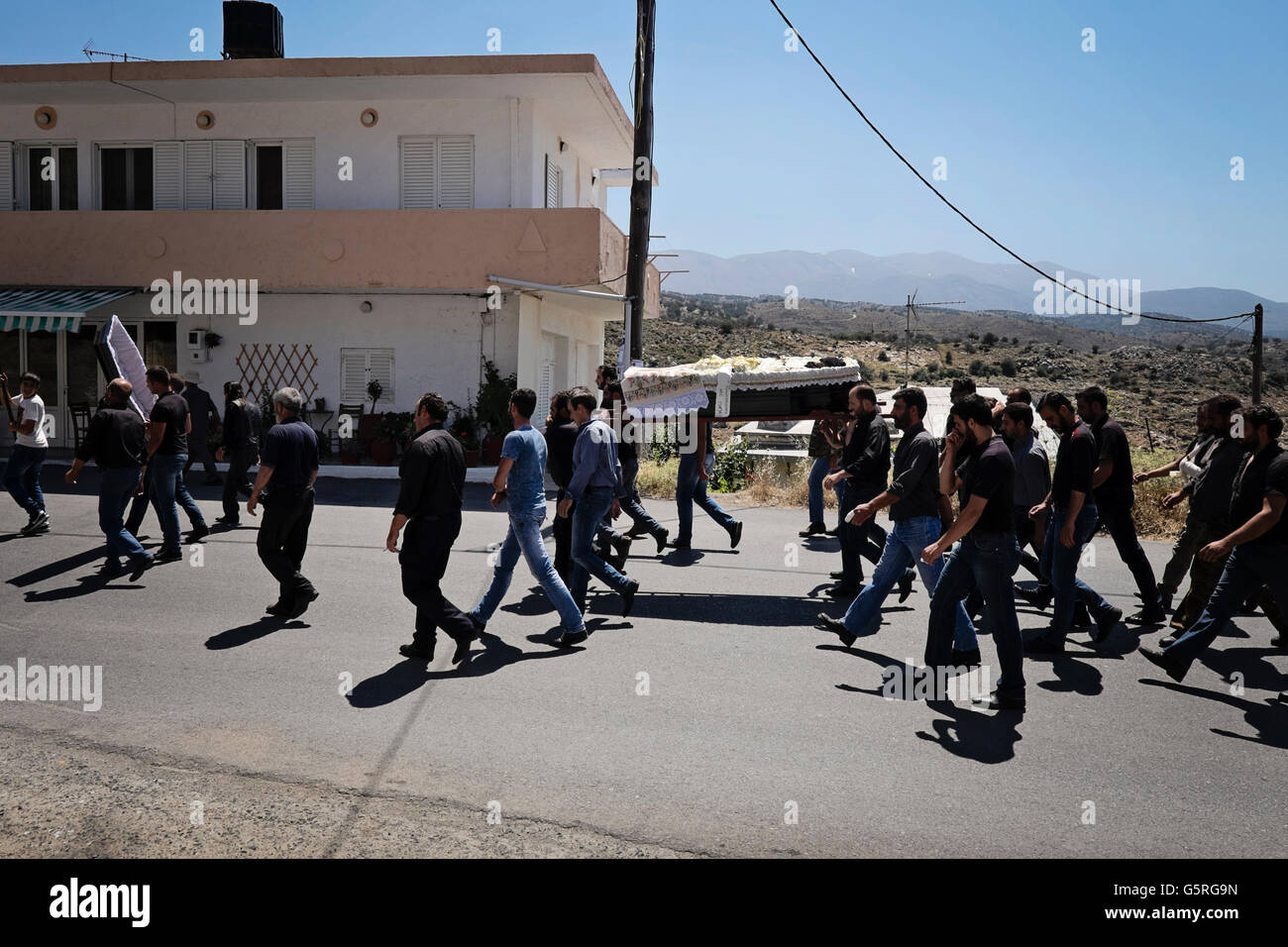 A funeral procession proceeds through the village of Anogia, on the ...