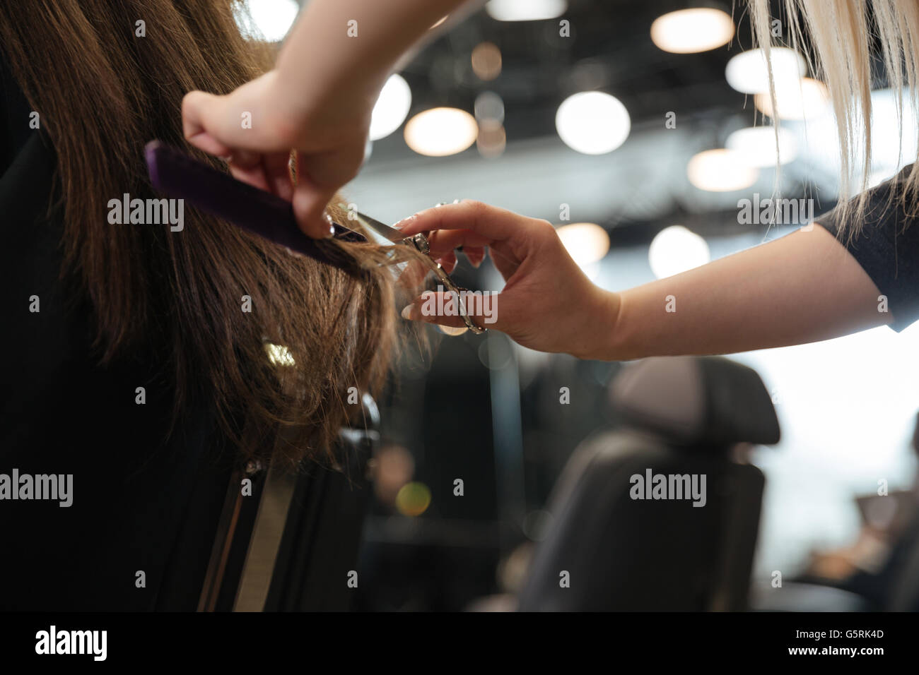 Professional hairdresser making stylish haircut at the beauty salon ...