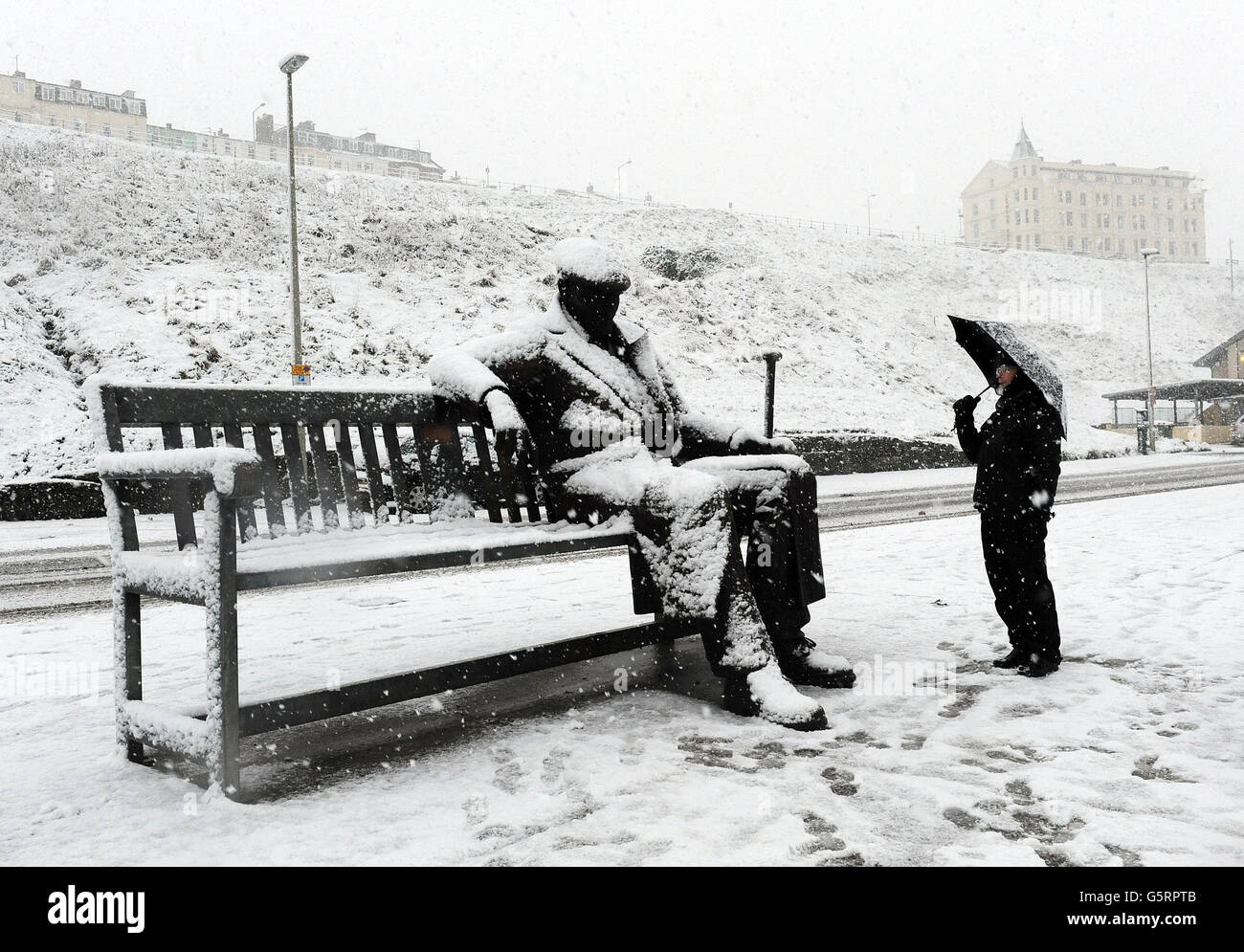 A man studies the snow covered Freddie Gilroy and the Belsen Stragglers ...