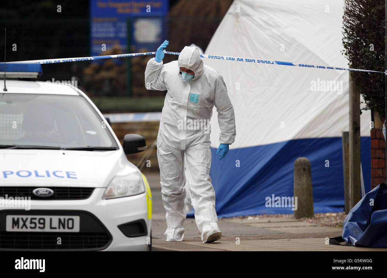 A police forensic officer works around the scene in Old Trafford ...