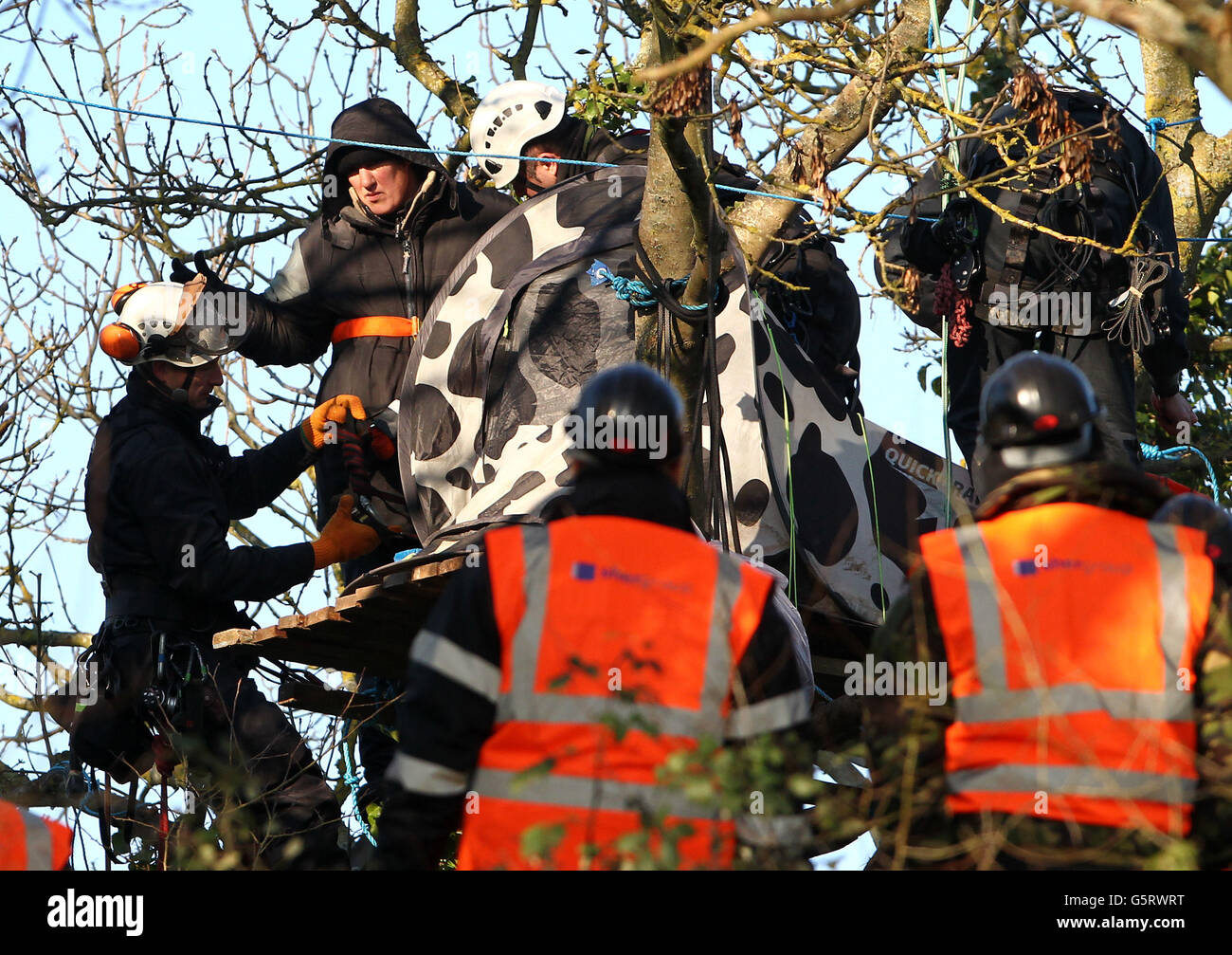 A road protestor (top left) is helped by rescue specialists as she ...