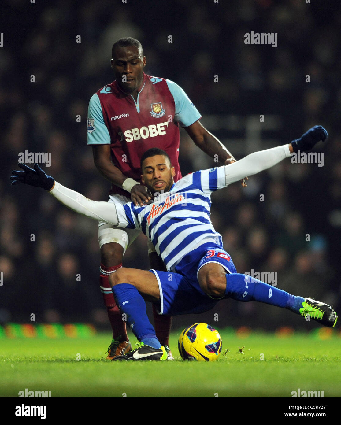 West Ham's Guy Demel (top) challenges QPR's Armand Traore during the ...