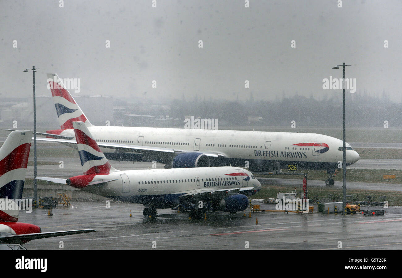 Planes maneuver in a snow shower at Heathrow Airport as the winter ...