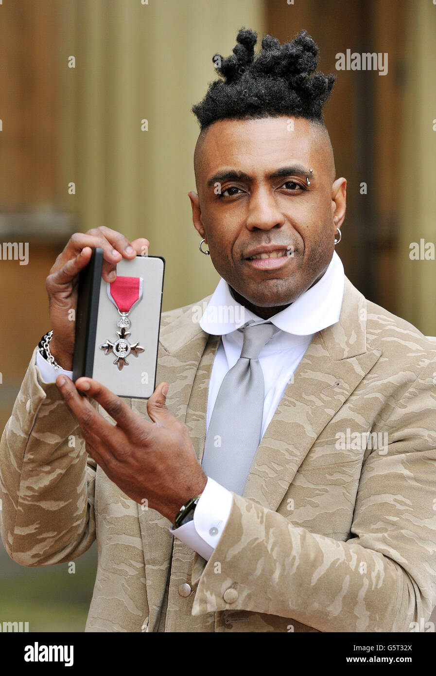 Omar Lyefook proudly holds his Member of the British Empire (MBE) medal ...