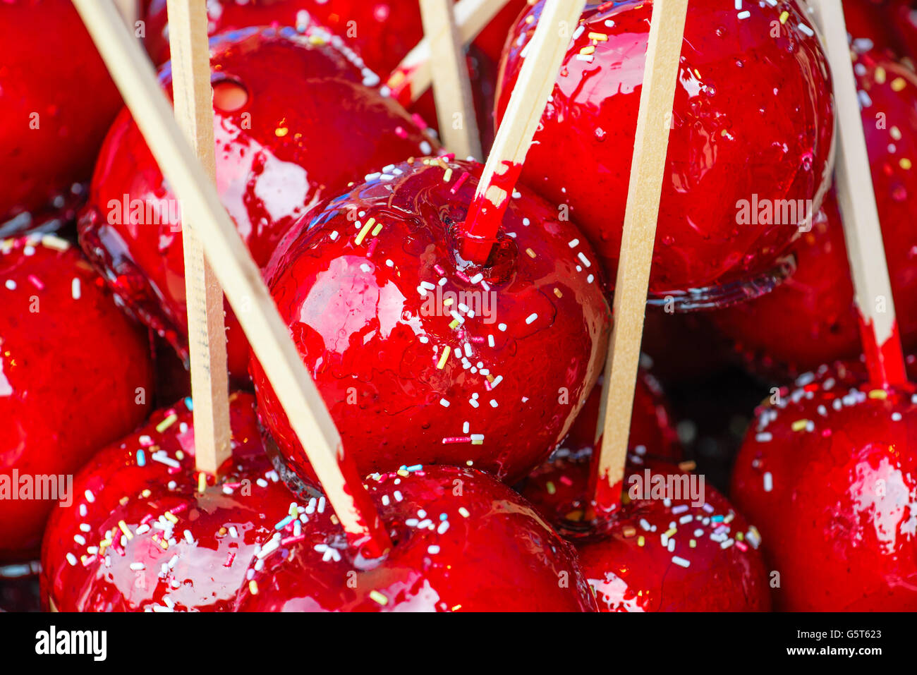 Sweet glazed red toffee candy apples on sticks for sale on farmer ...