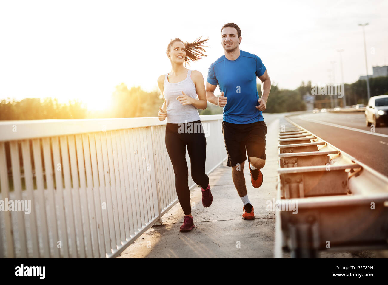 Active couple jogging outdoors during sunset Stock Photo - Alamy