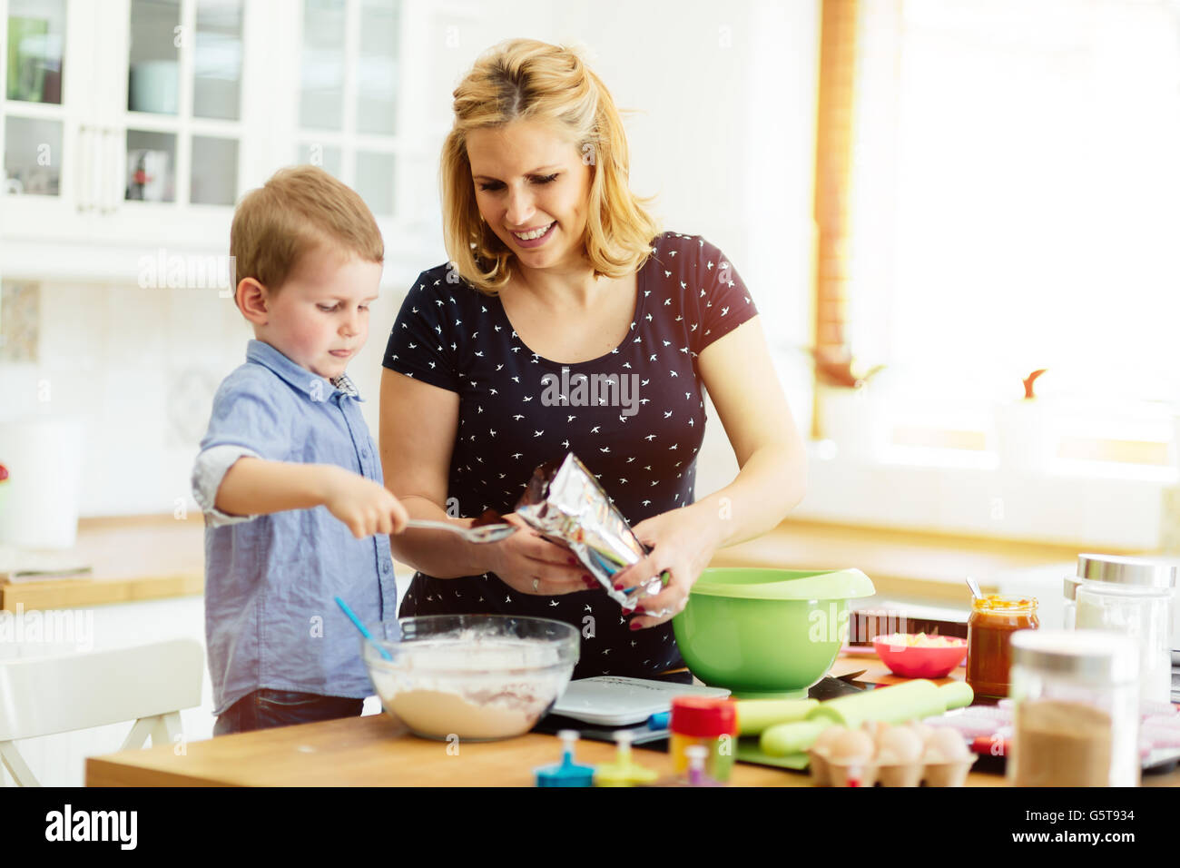Child helping mother make cookies in modern kitchen Stock Photo - Alamy