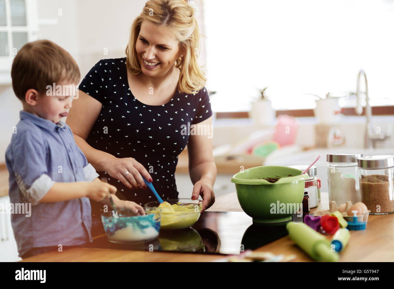 Child helping mother make cookies in modern kitchen Stock Photo - Alamy