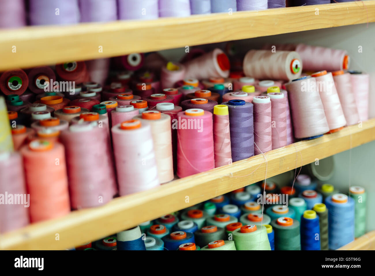 Colorful thread spools in fabric industry Stock Photo - Alamy