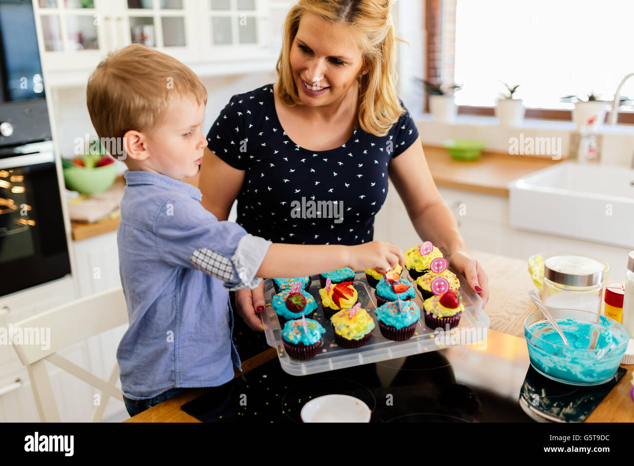Child helping mother make cookies in modern kitchen Stock Photo - Alamy