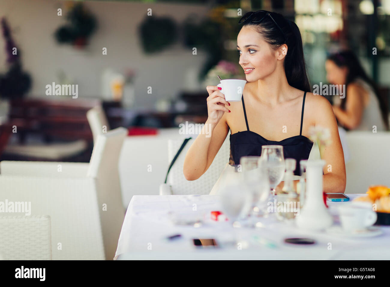 Beautiful young women drinking tea in restaurant Stock Photo - Alamy