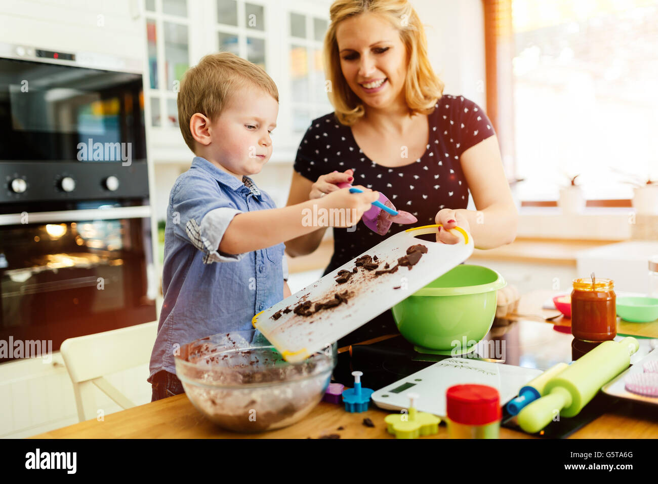 Beautiful child and mother baking in kitchen with love Stock Photo - Alamy