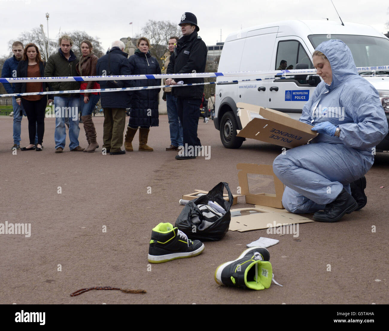 A scenes of crime officer documents evidence from the scene between the ...