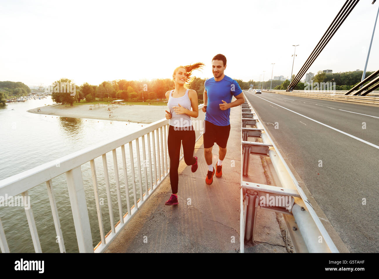 Active couple jogging outdoors during sunset Stock Photo - Alamy