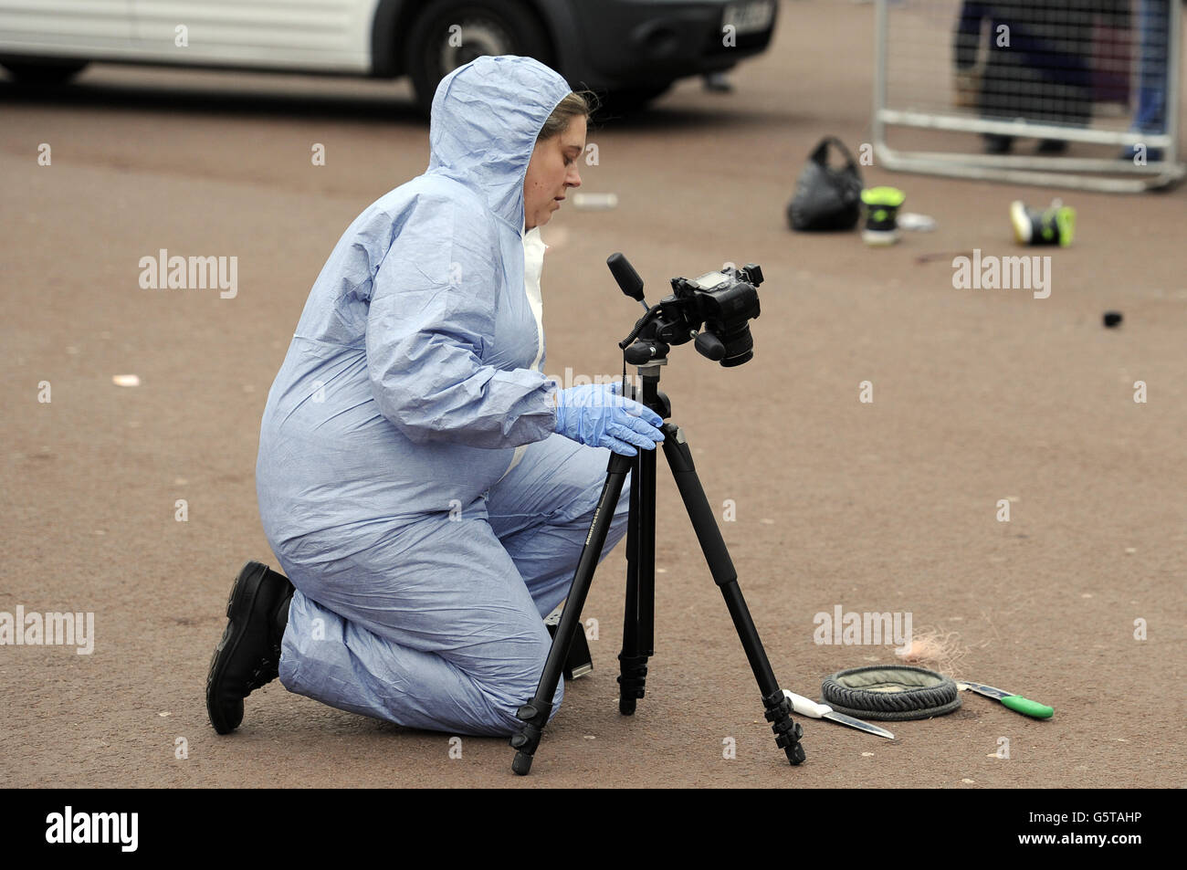 A scenes of crime officer documents evidence from the scene between the ...