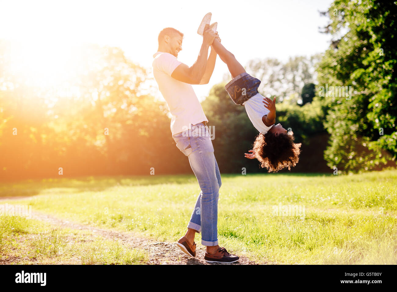 Father swinging daughter outdoors in beautiful nature Stock Photo - Alamy