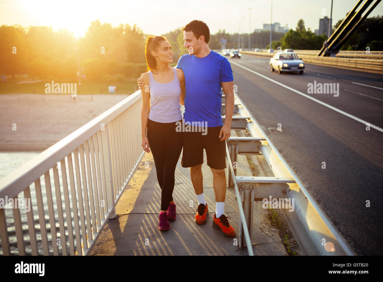 Beautiful couple bonding during mutual exercise on city bridge Stock ...