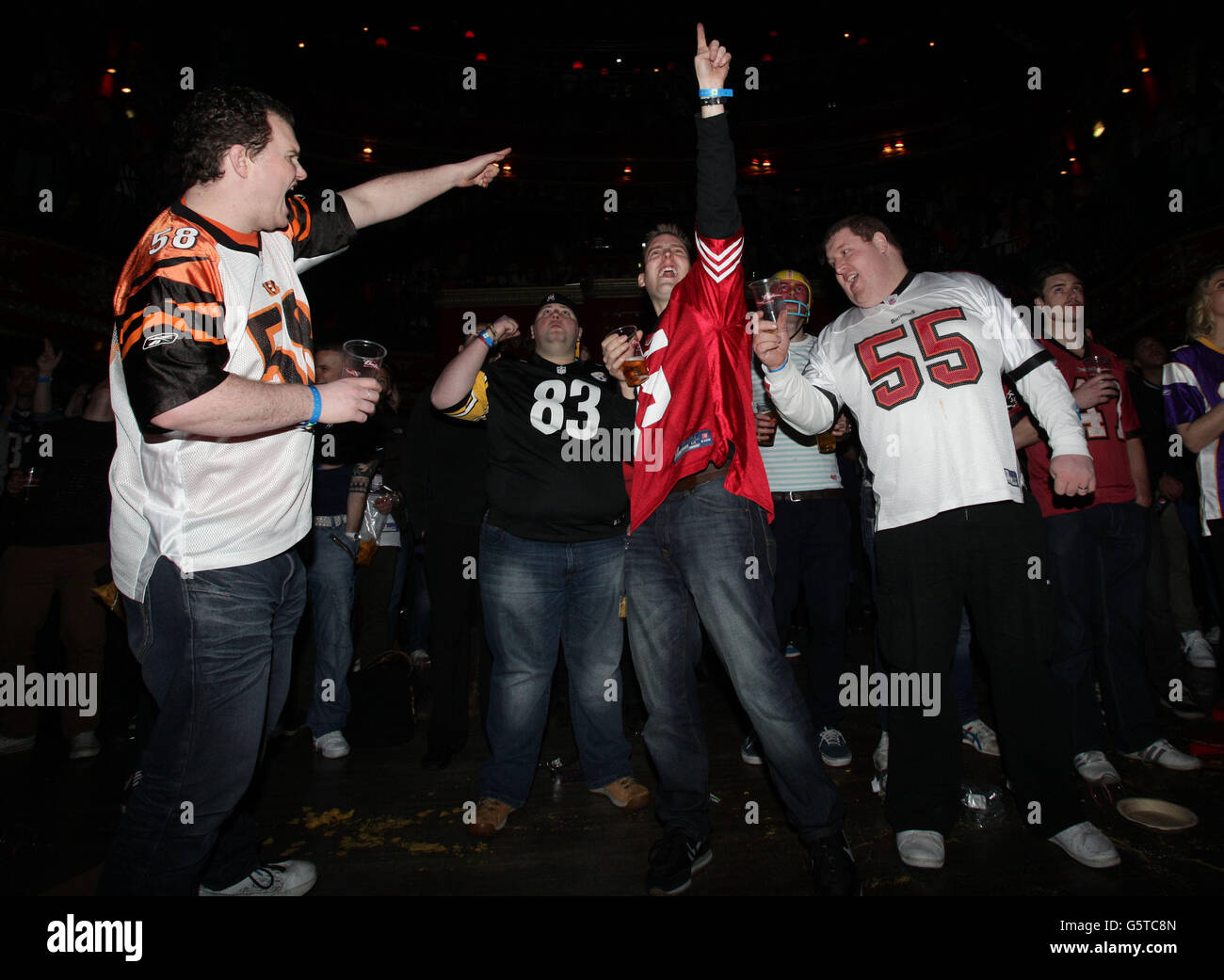 Fans react whilst watching the game on a giant screen, during the NFL ...