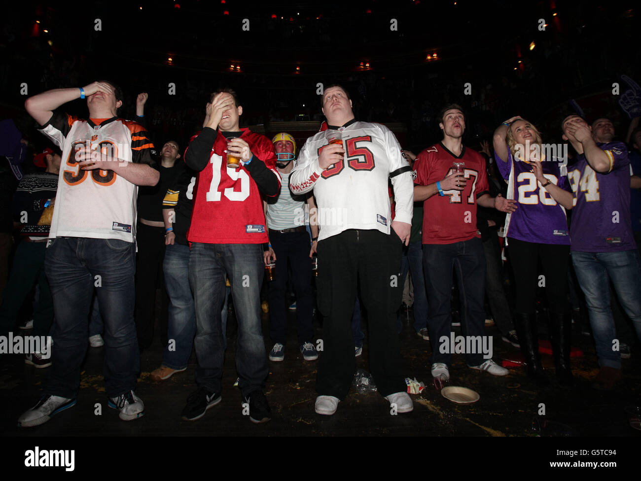 Fans react whilst watching the game on a giant screen, during the NFL ...